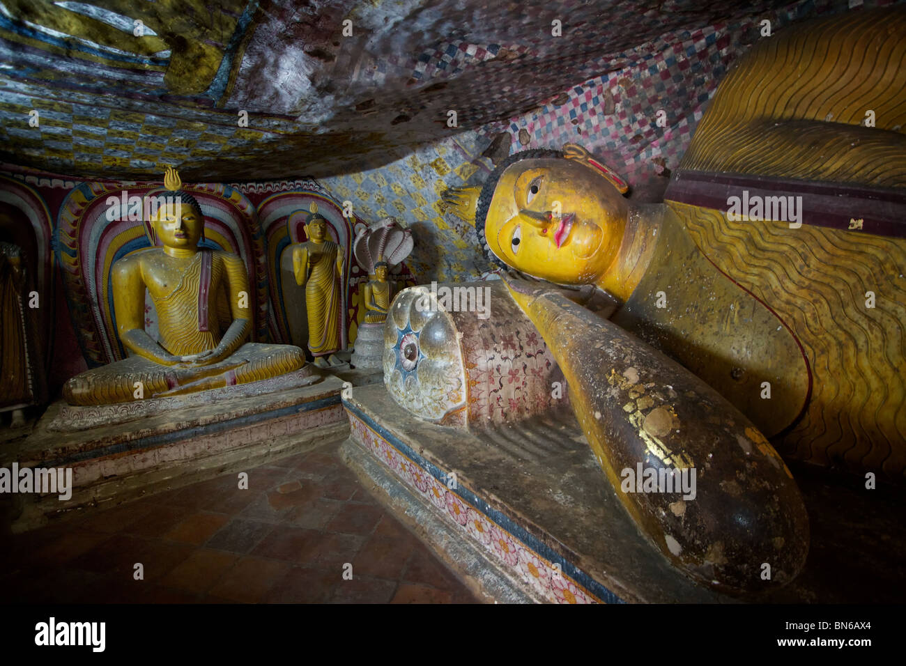 line of buddha statues seated and reclining in a dambulla cave Stock ...