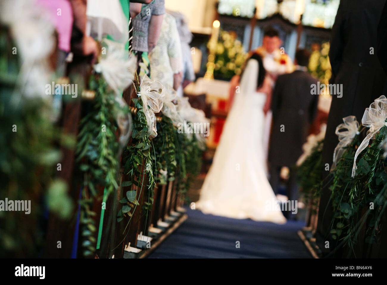 Bride and groom standing at altar at end of isle in a traditional UK ...