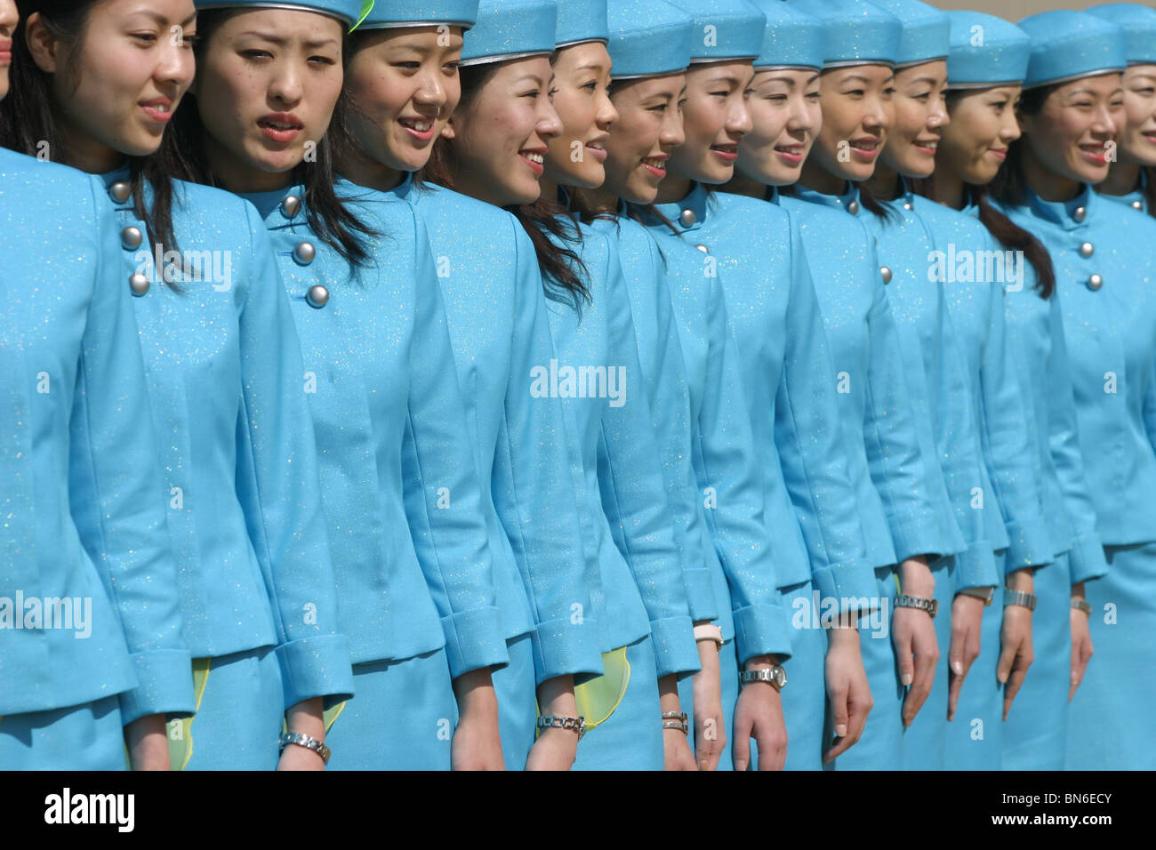 Japanese women wearing corporate uniforms greet visitors at the ...