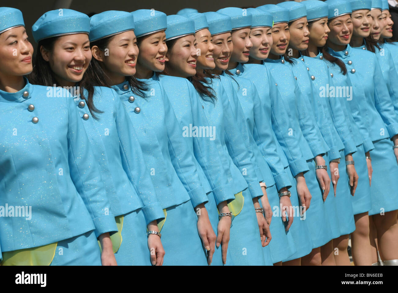 Japanese women wearing corporate uniforms greet visitors at the ...