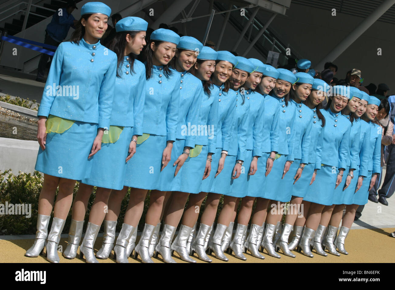 Japanese women wearing corporate uniforms greet visitors at the ...