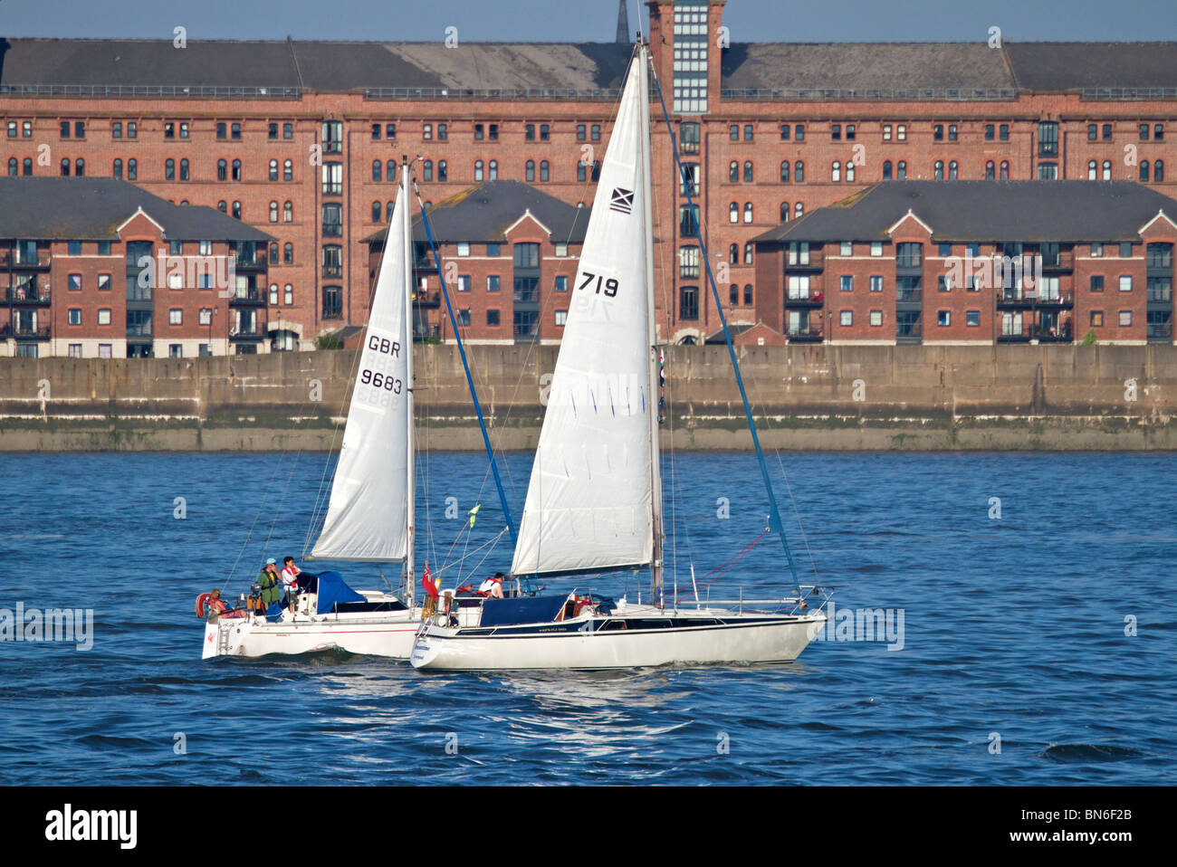 Two small sailing boats racing in river Mersey on a bright sunny ...