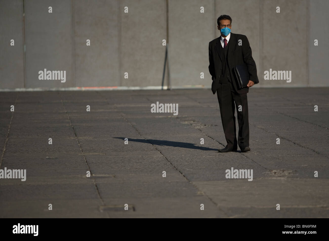 A man wears a mask as a precaution against swine flu in the Zocalo ...