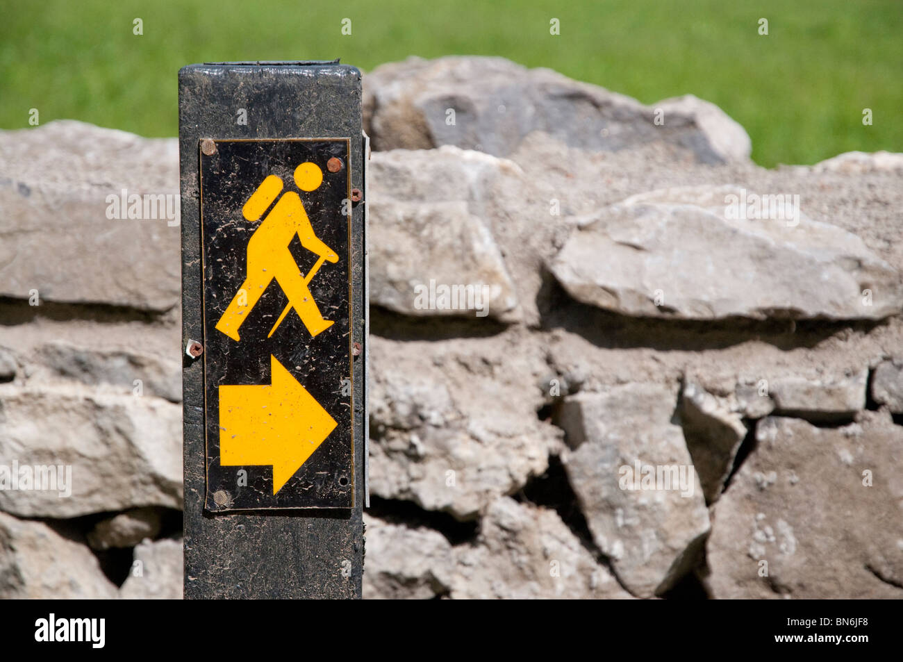 Walking route sign in Ireland, in front of a dry stone wall Stock Photo ...