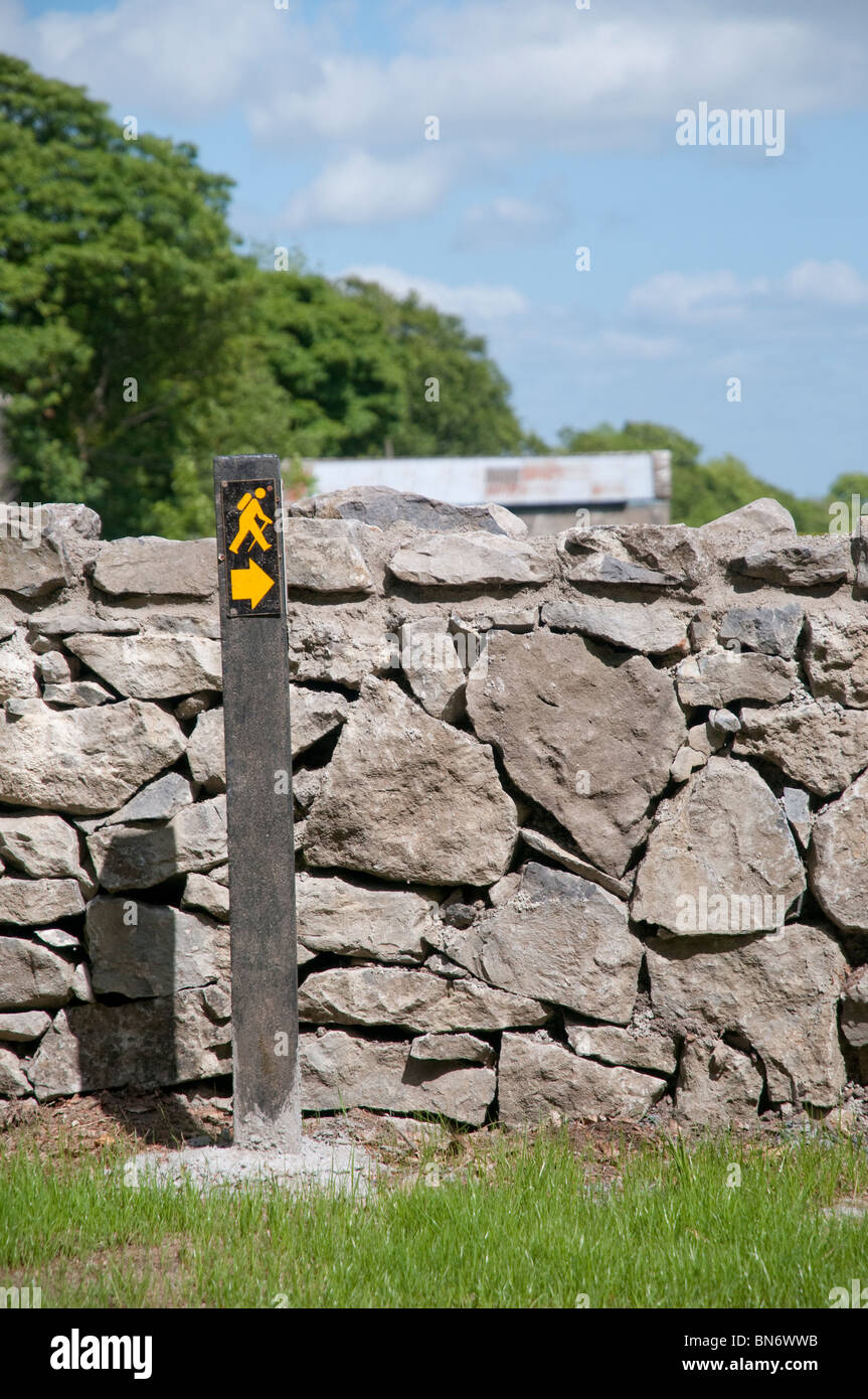Walking route sign in Ireland, in front of a dry stone wall Stock Photo ...
