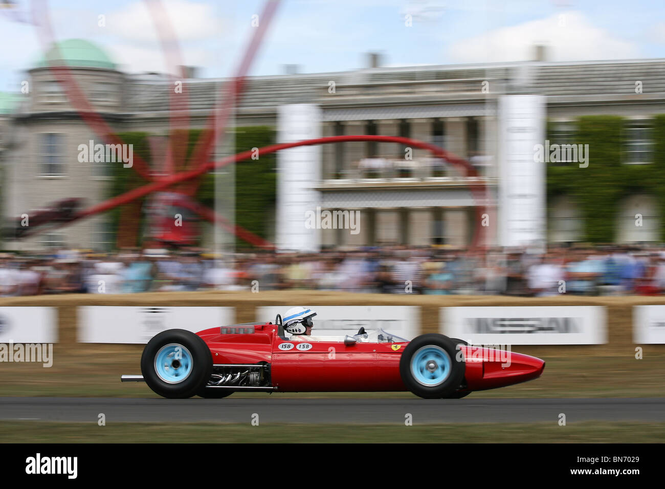 Sir John Surtees in an historic Ferrari Grand Prix F1 car powers past ...