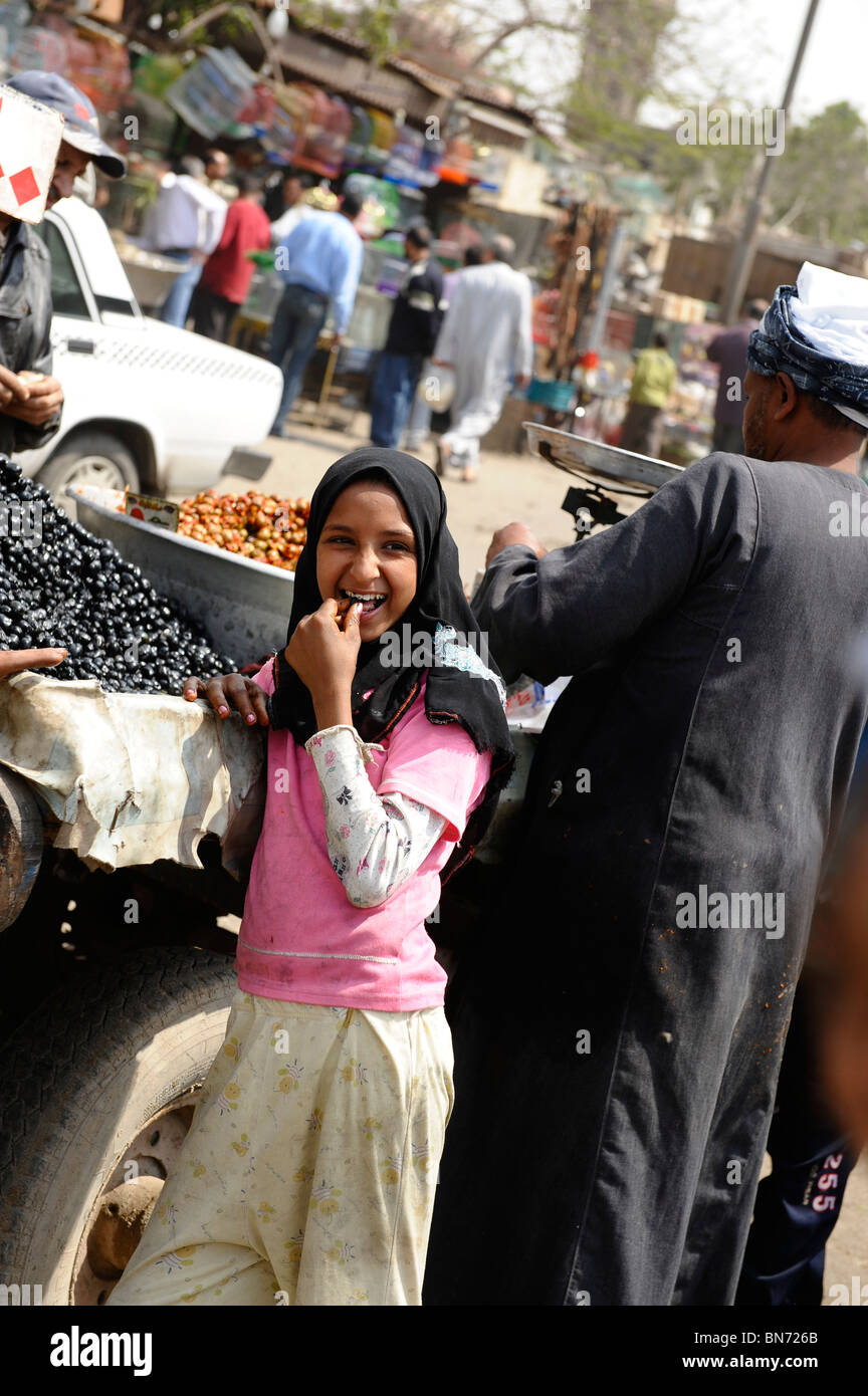 happy egyptian girl eating olives , souk goma (friday market), Southern ...