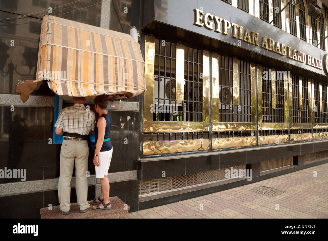 Two tourists getting money from an ATM, the Egyptian Arab Land Bank ...
