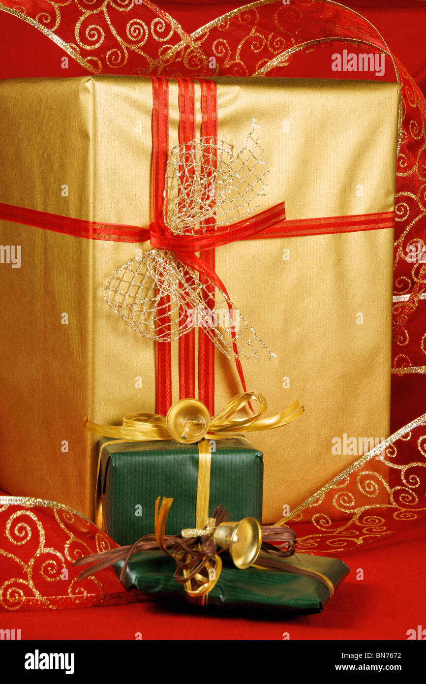 Some Christmas presents with decorations and ribbon over a red ...