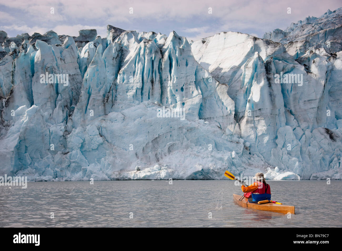 Man kayaking in a self made wooden kayak in front of Shoup Glacier ...