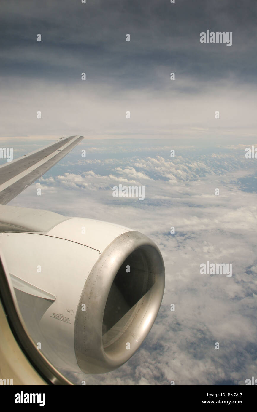 View from airplane window, with view of wing and jet engine, over blue ...