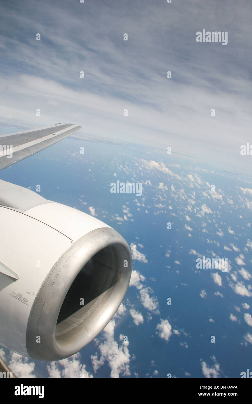 View from airplane window, with view of wing and jet engine, over blue ...
