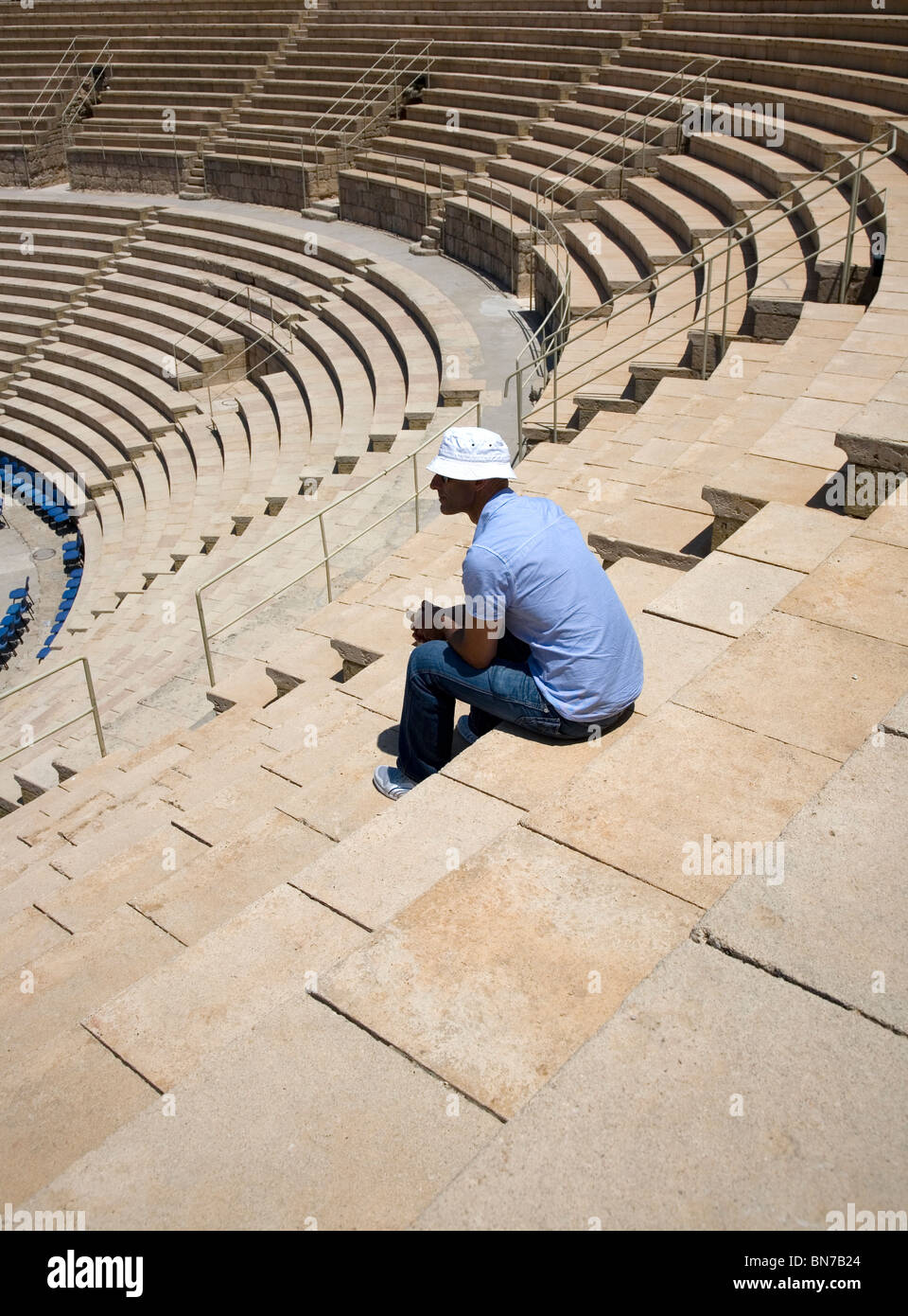 Man sitting in the amphitheater at Caesarea National Park Stock Photo ...
