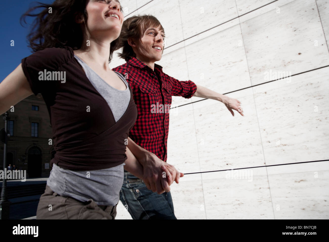 Happy young couple jumping Stock Photo - Alamy