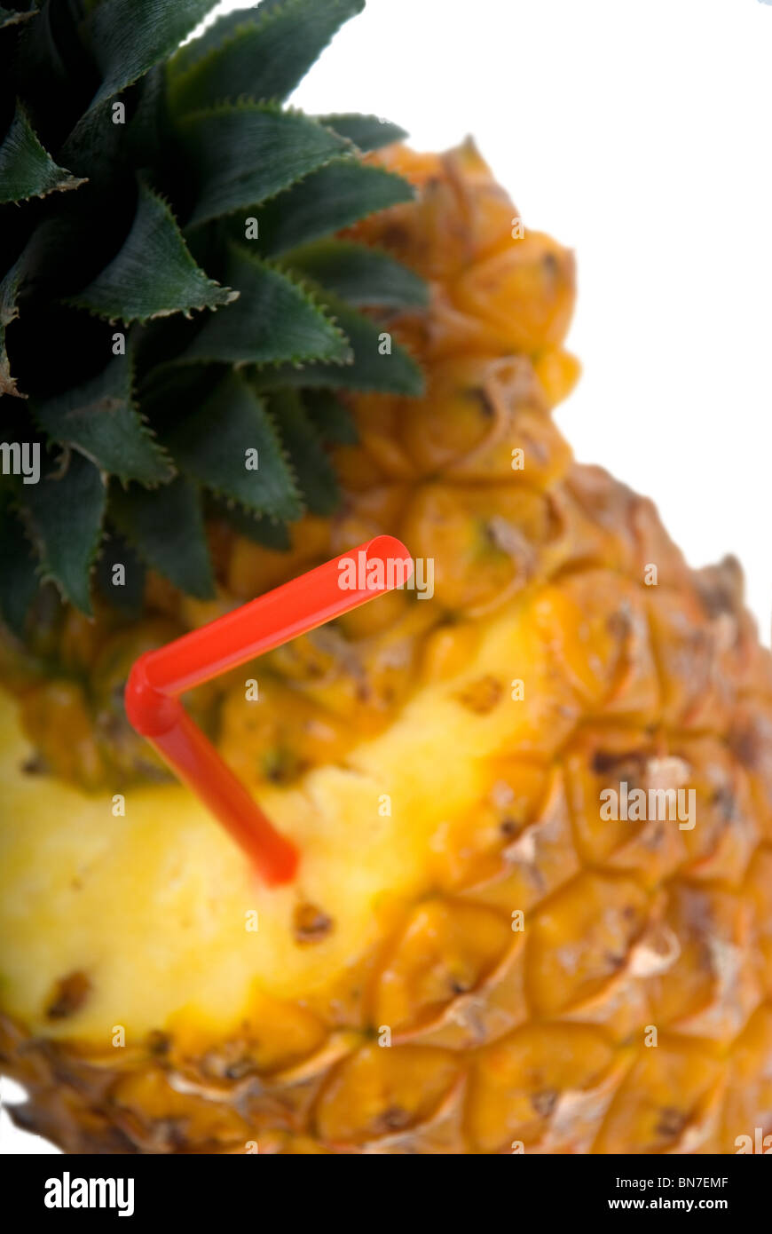 ripe pineapple cutted on top with red and blue straws isolated on white ...