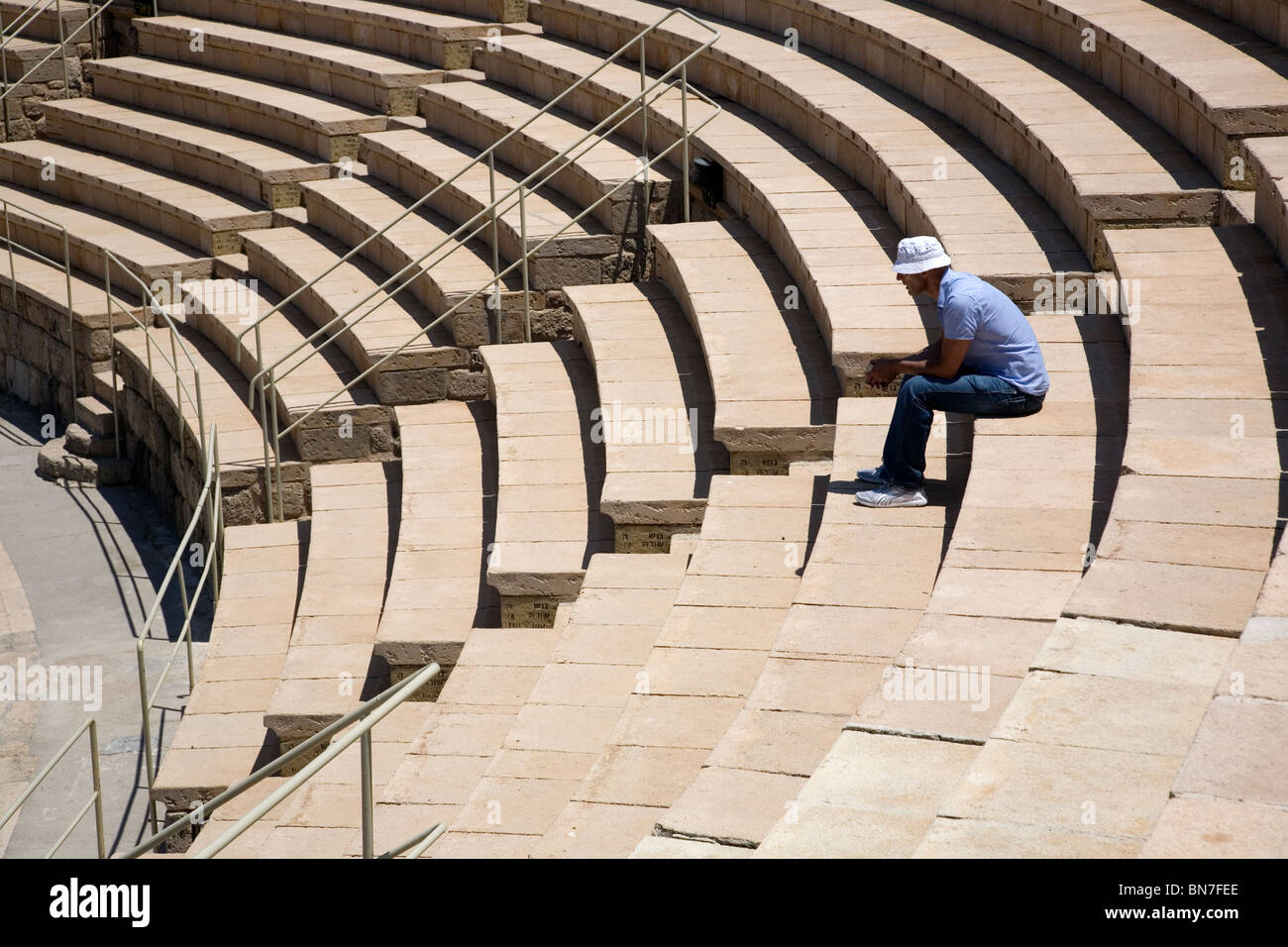 Man sitting in the amphitheater at Caesarea National Park Stock Photo ...