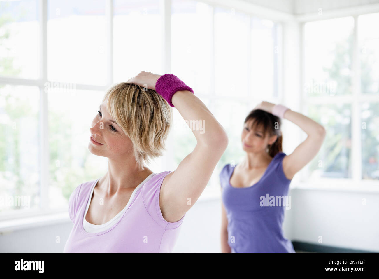 Two women stretching neck Stock Photo - Alamy