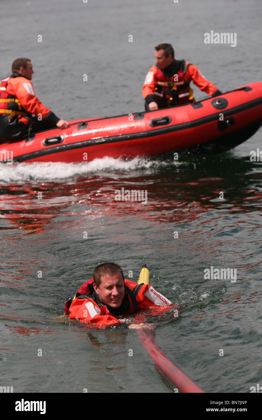 fireman training to save a person who is drowning in open water. they ...