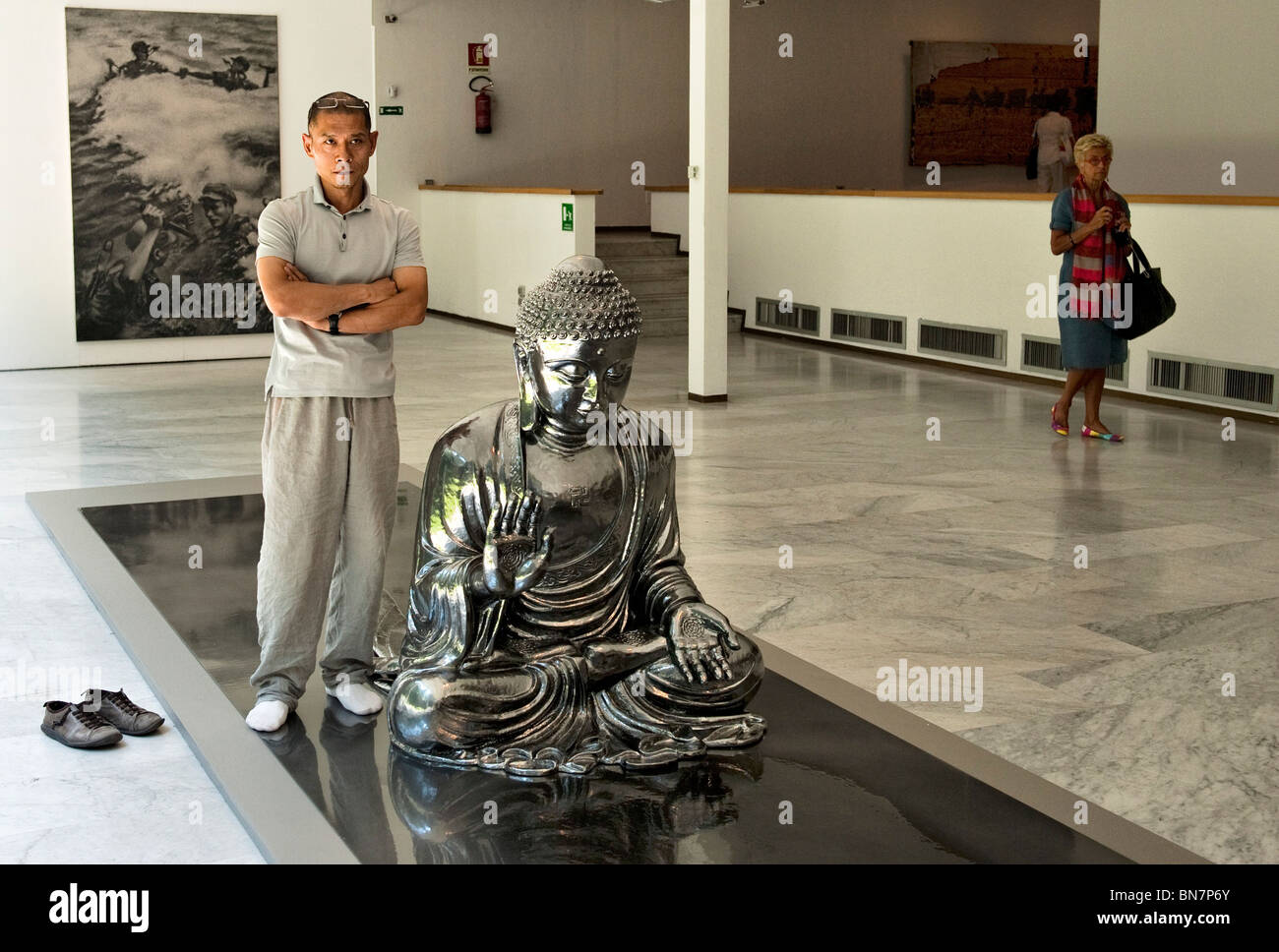 Chinese artist Zhang Huan posing by his sculpture "Buddha of Steel Life ...