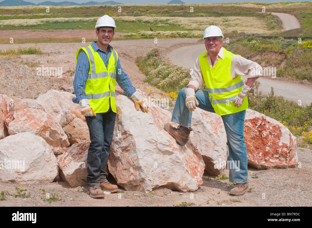 Hispanic construction workers standing near boulders Stock Photo - Alamy