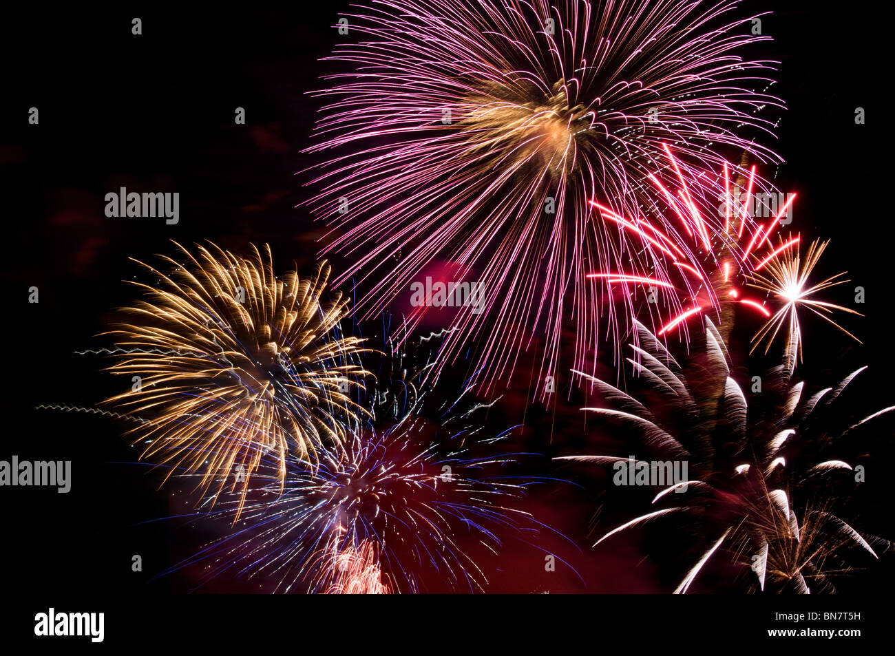 Multiple bursts of fireworks fill the night sky in a dazzling ...