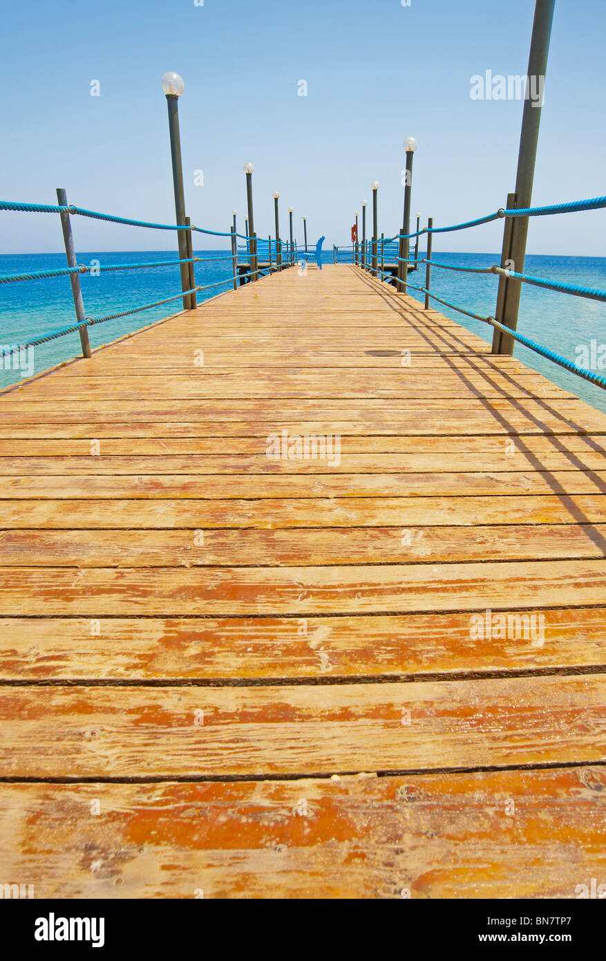 A small wooden jetty going into the sea from a tropical beach Stock ...
