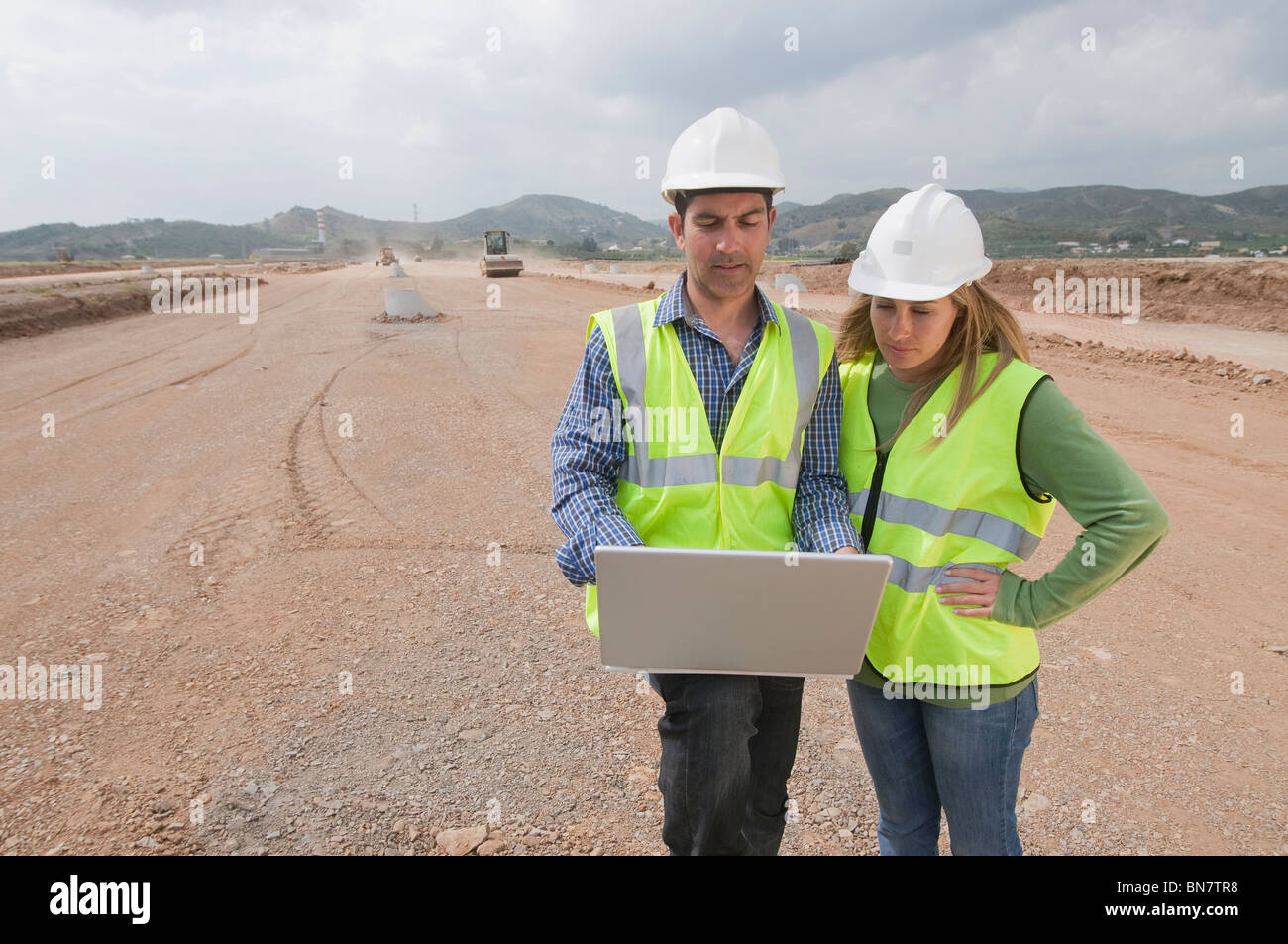 Hispanic construction workers using laptop in field Stock Photo - Alamy