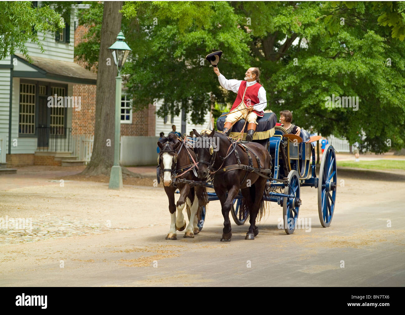 Tourists enjoy a horse-drawn carriage ride through the streets of ...