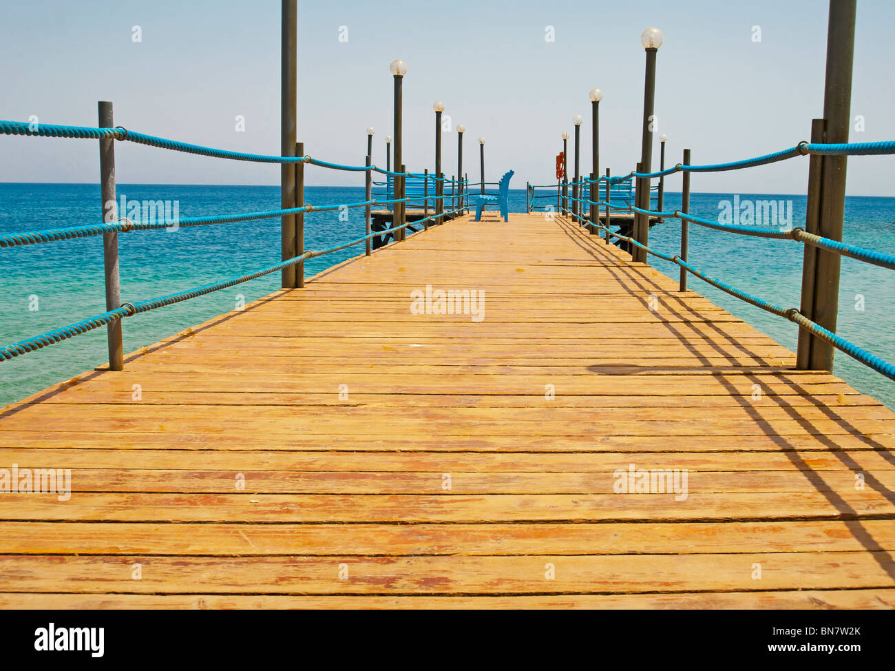 A small wooden jetty going into the sea from a tropical beach Stock ...