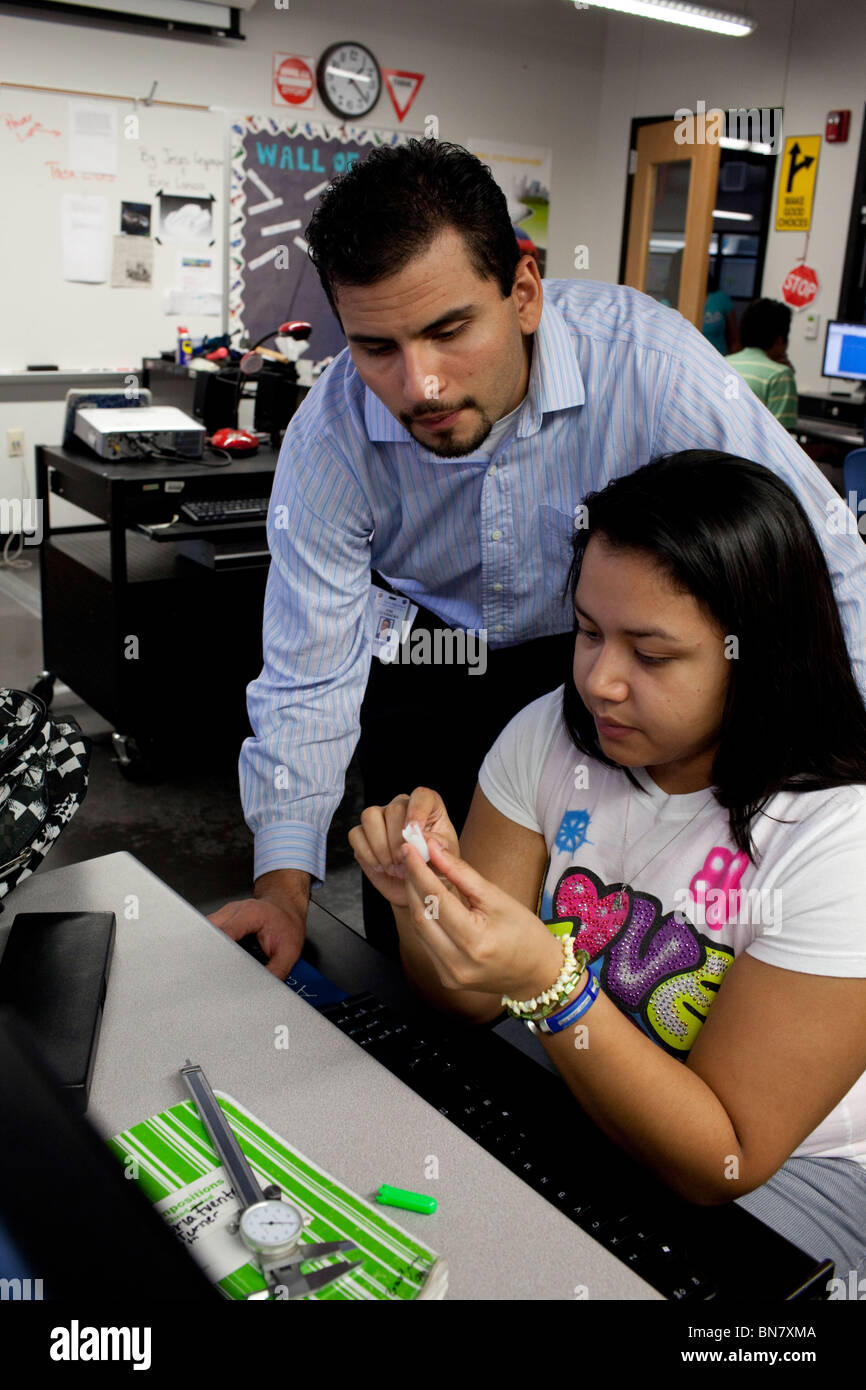 Female Hispanic high school student gets help from male Hispanic ...