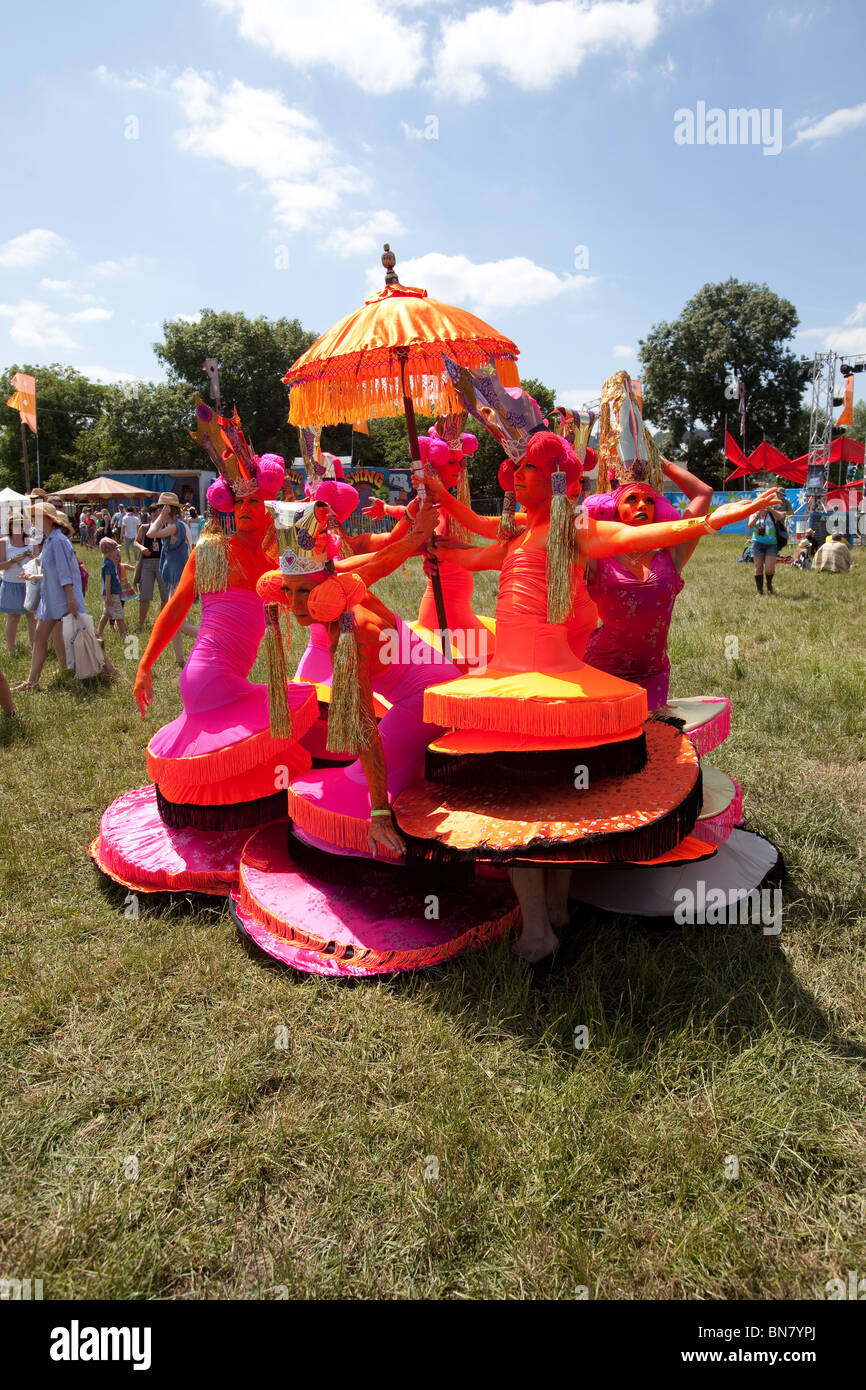 Bright orange cabaret performers in the circus field at the Glastonbury ...