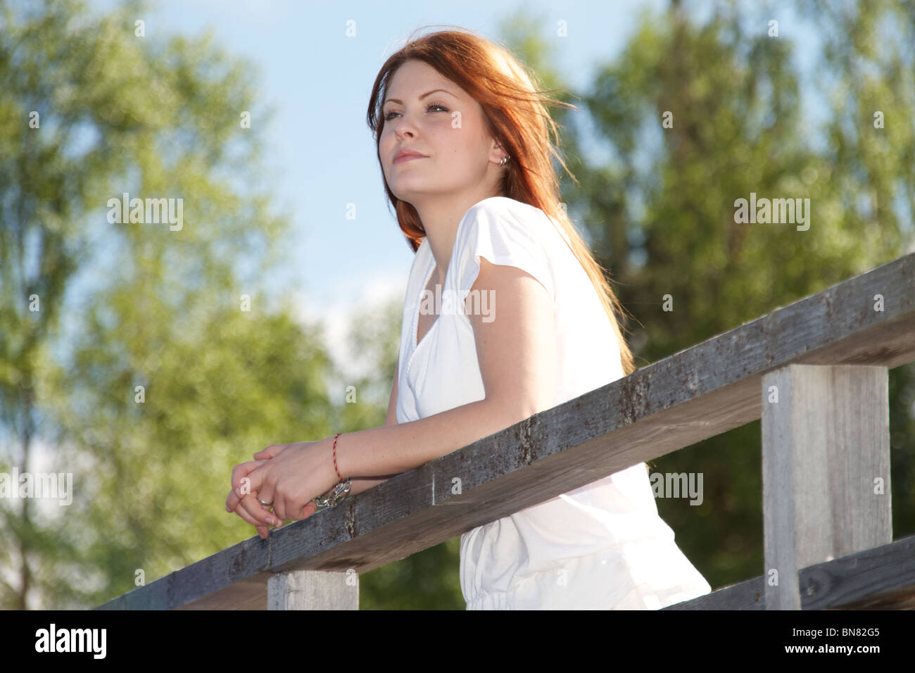 Woman leaning on a bridge Stock Photo - Alamy