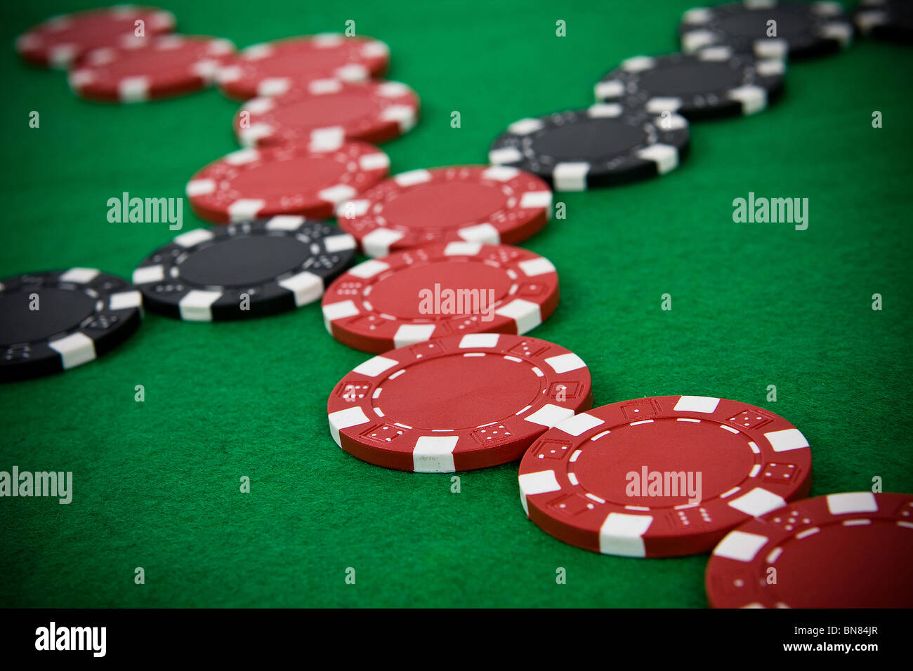 Crossed lines of red and black poker chips on green poker table Stock ...