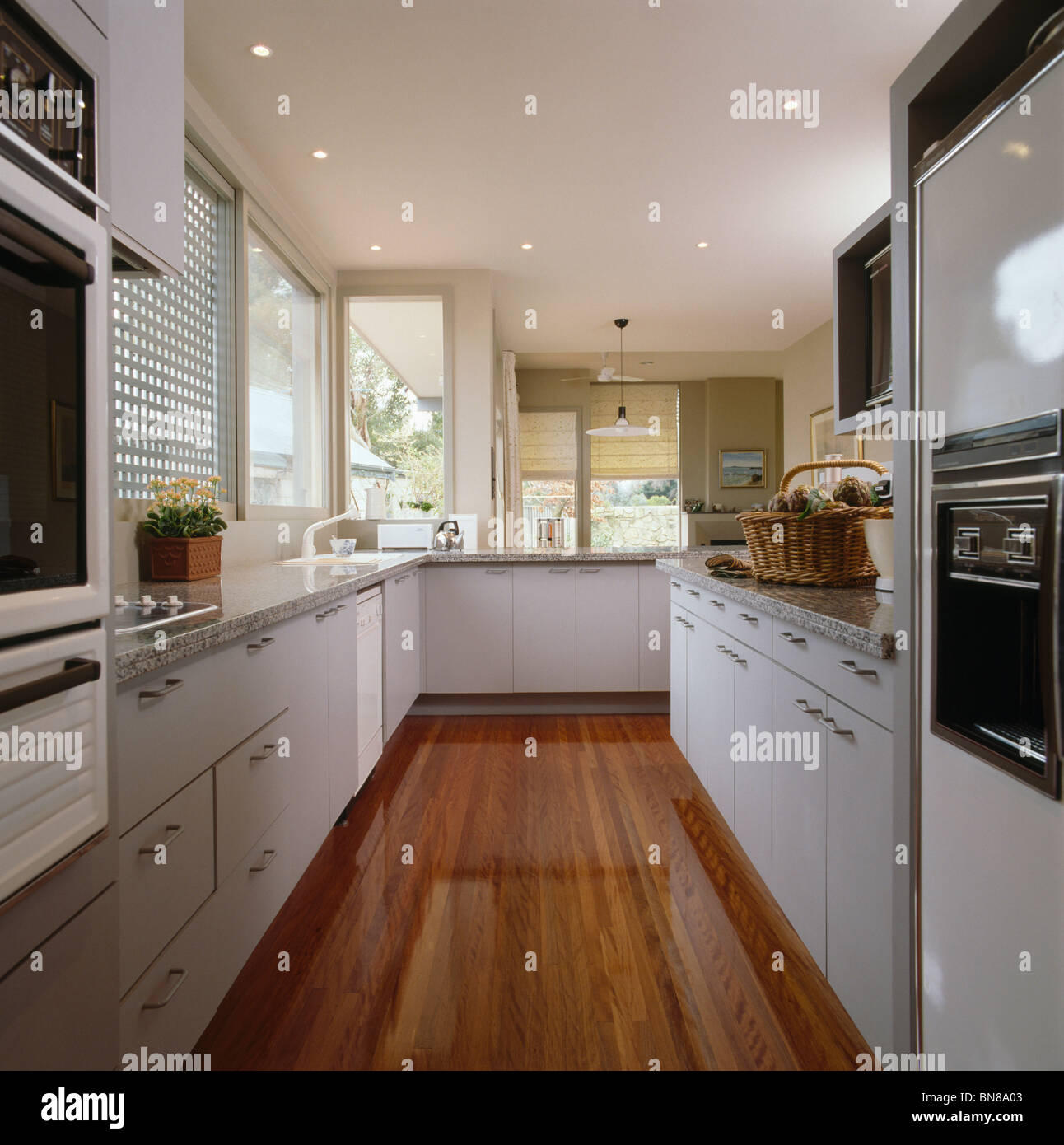 Wooden flooring in large modern white kitchen Stock Photo - Alamy