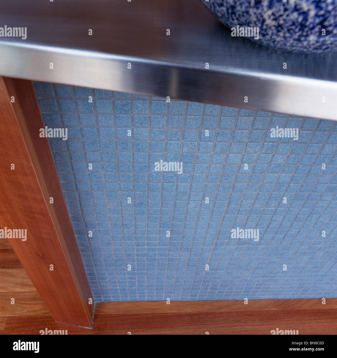 Close-up of blue mosaic tiled kitchen unit with stainless steel worktop ...
