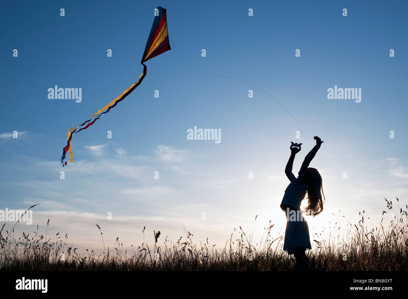Young Girl having fun flying a multicoloured kite in the English ...