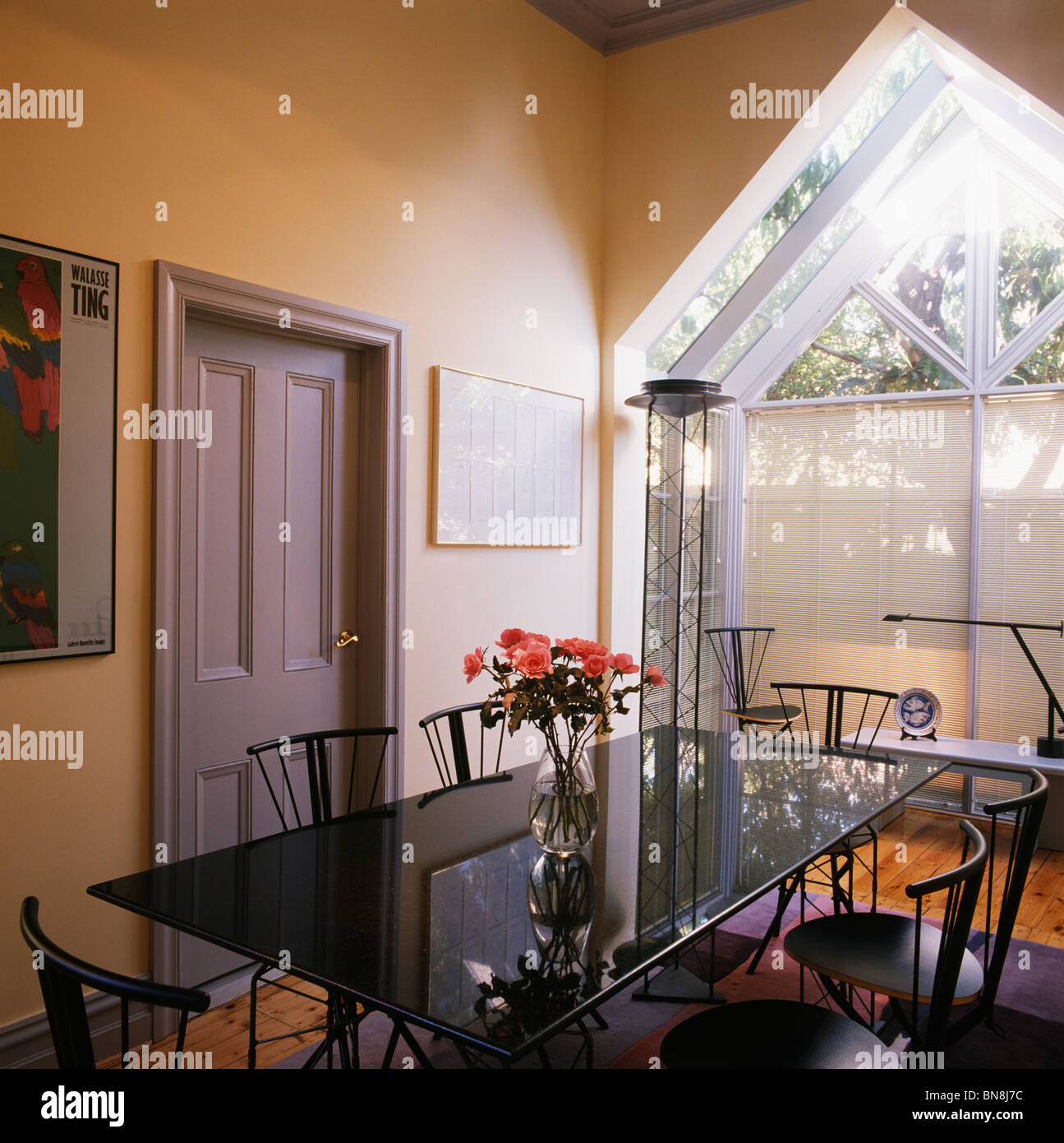 Black glass table and metal chairs in modern dining room with blind on ...