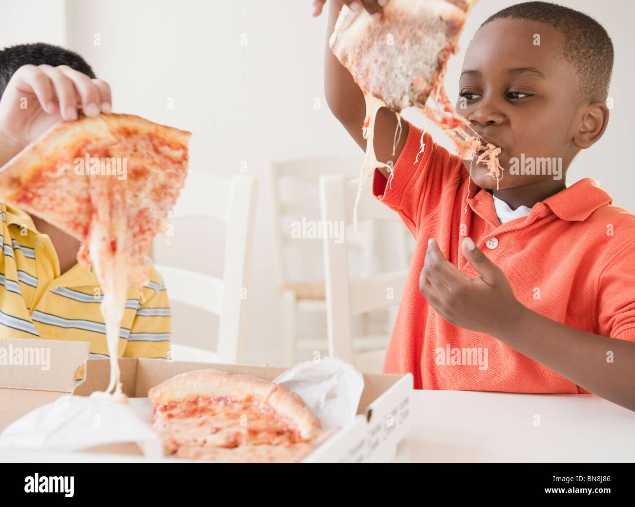 Boys eating pizza together Stock Photo - Alamy