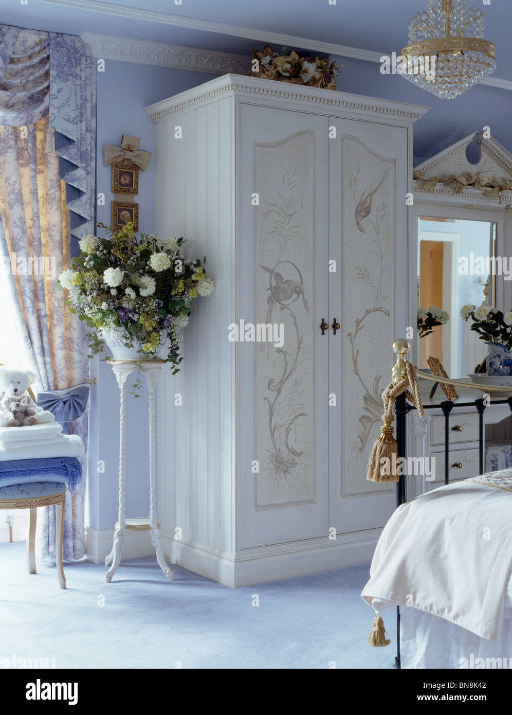 Hand-painted and decorated blue wardrobe in blue bedroom with flower ...