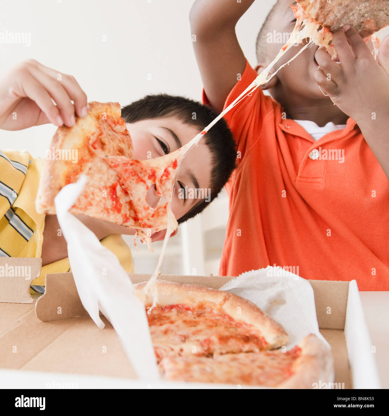 Boys eating pizza together Stock Photo - Alamy
