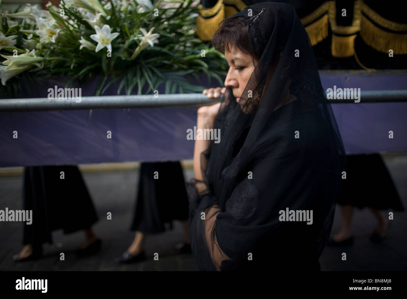A woman carries a Virgin Mary statue during holy week celebrations in ...