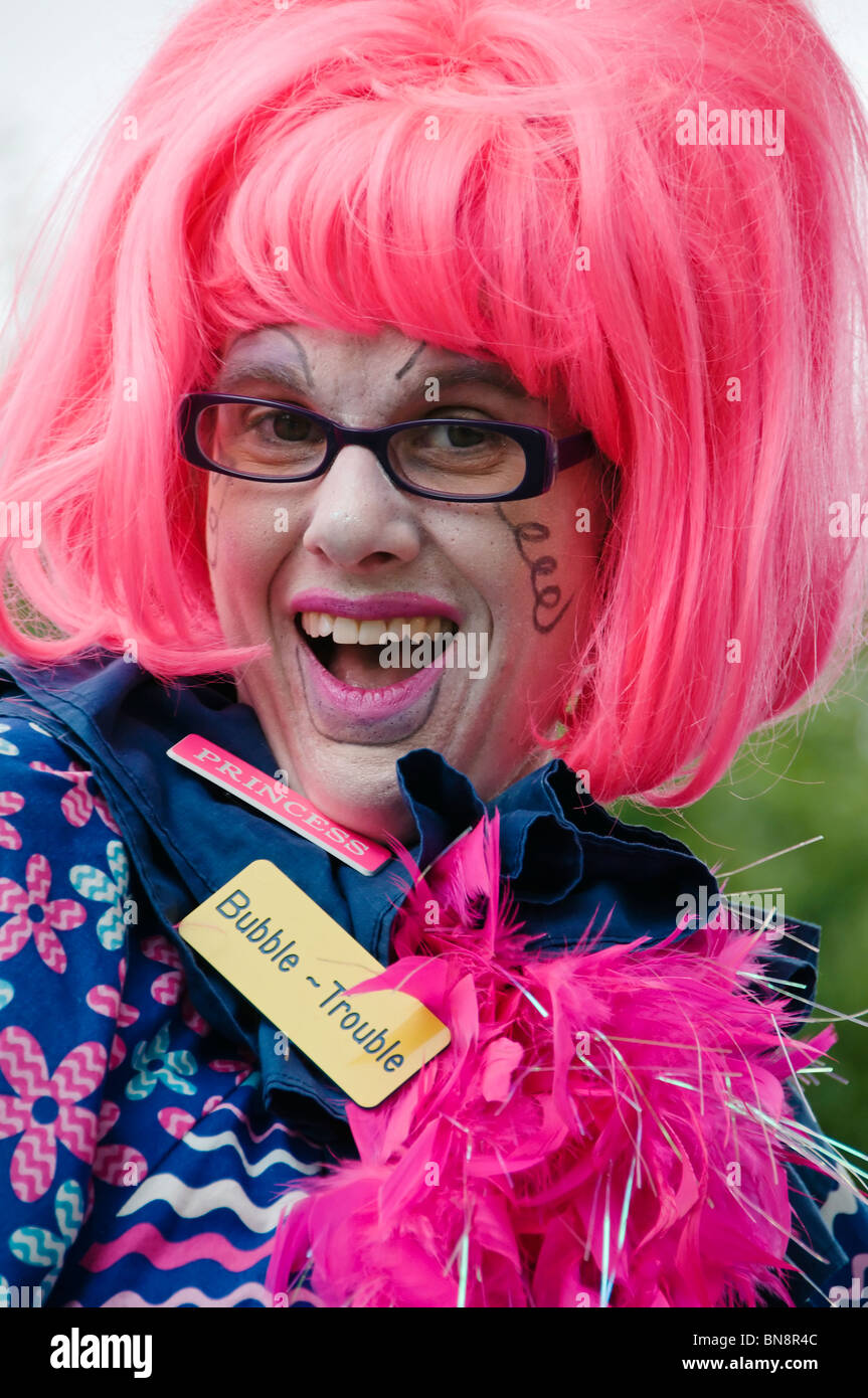 A playful clown in a bright pink wig posses during the 4th of July ...