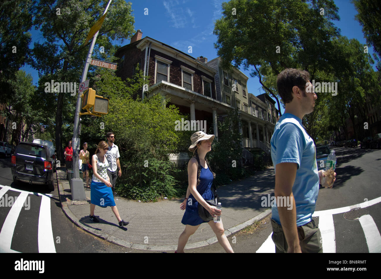 People walk past wooden houses in the Fort Greene neighborhood of ...