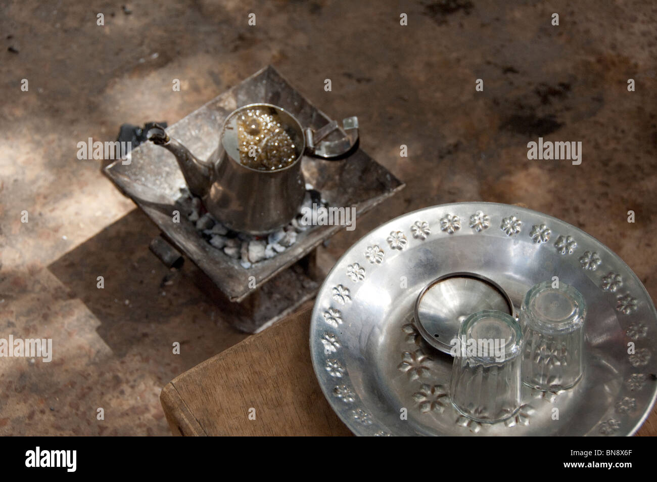 Africa, Gambia. Capital city of Banjul. Tea boiling in metal pot on hot ...