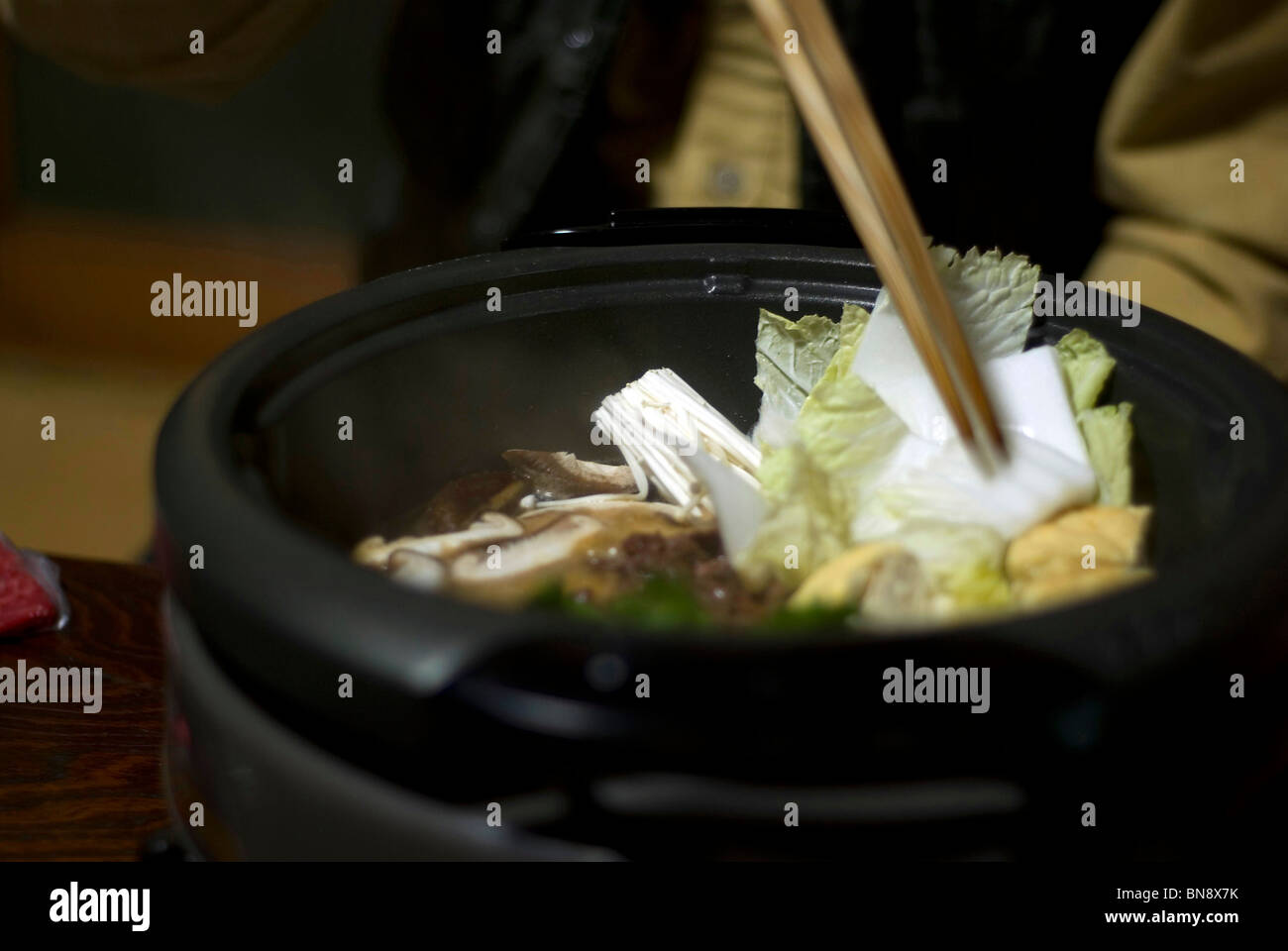 A Japanese man makes traditional food at a low table Stock Photo - Alamy