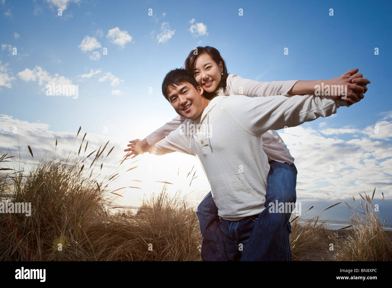 Korean man giving girlfriend piggyback ride Stock Photo - Alamy