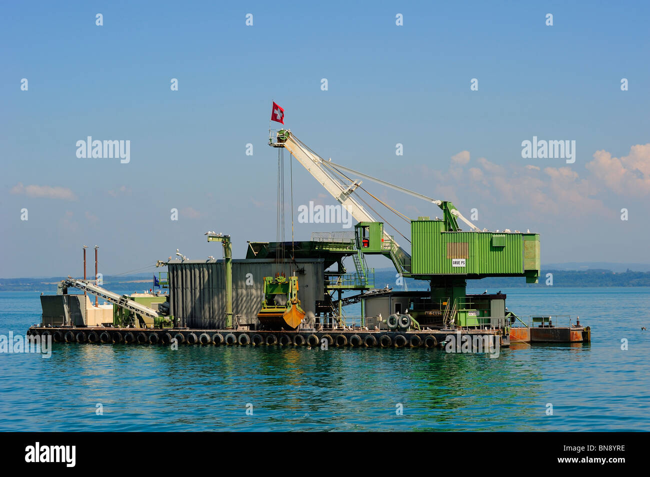 Gravel dredger on the Lac de Neuchatel, flying the Swiss flag Stock ...