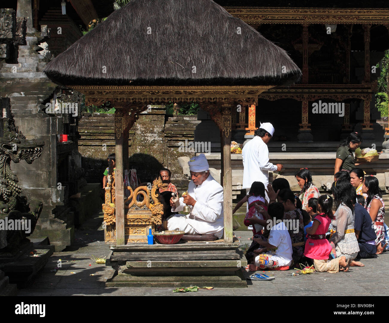 Balinese priest, conducting a ceremony at Tirta Empul Temple, a second ...