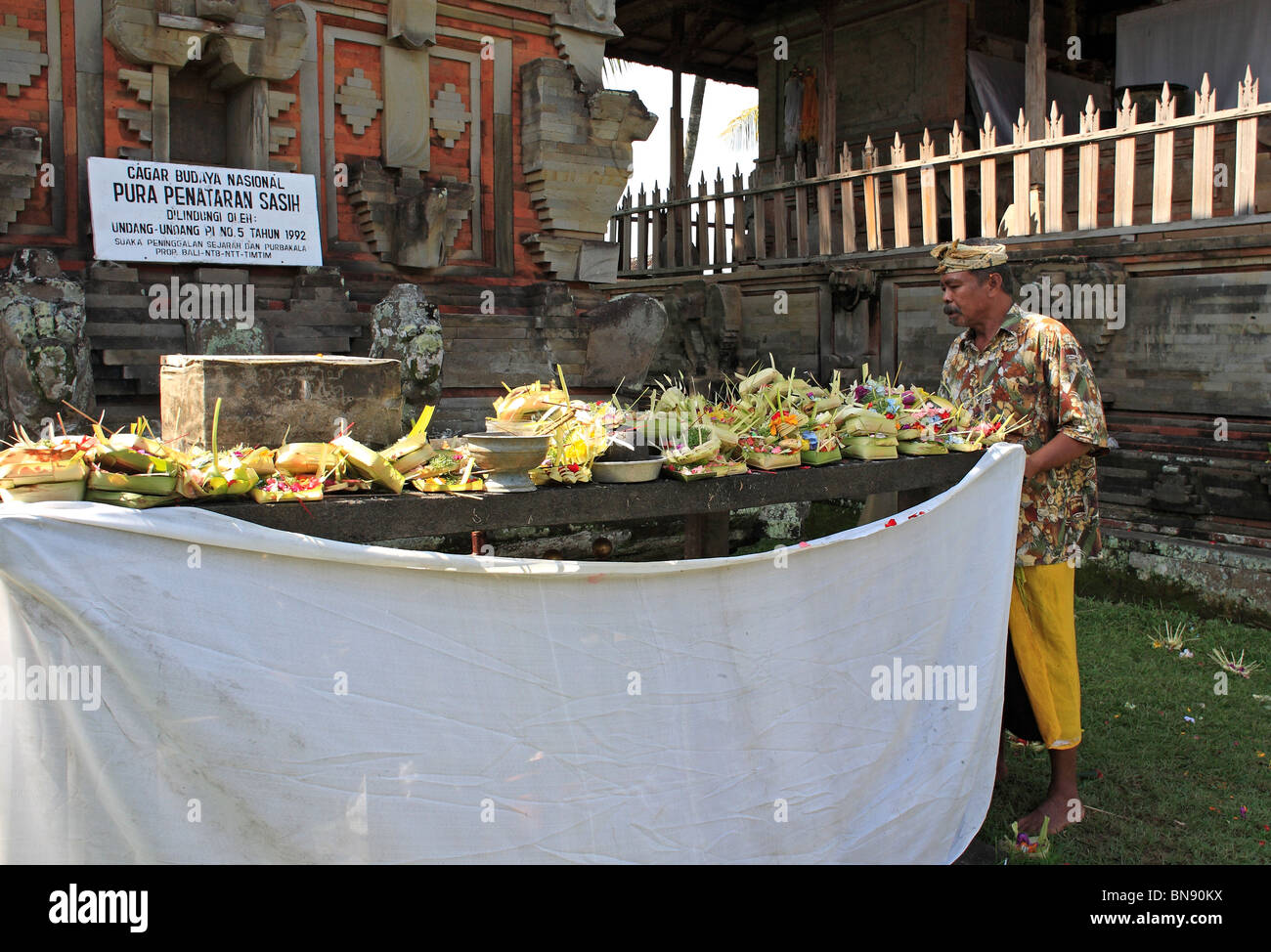 Balinese priest, or holy man collecting money left in offerings made by ...