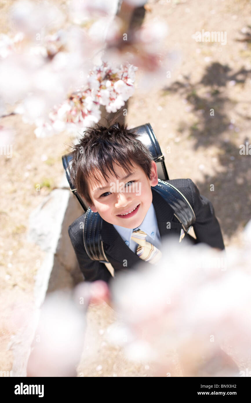 Boy standing under tree smiling hi-res stock photography and images - Alamy